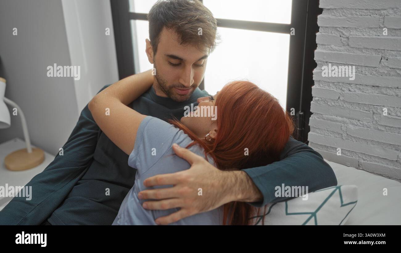 Couple embracing lovingly on bed in cozy bedroom with soft lighting enhancing warm connection ...