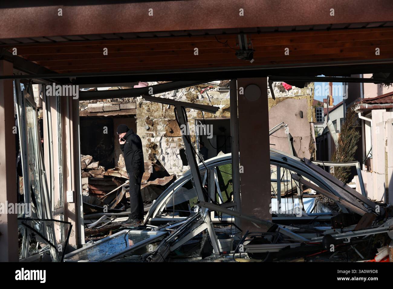 A man stands amid the rubble of a private residential building damaged ...