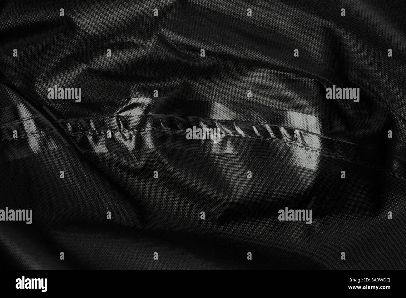 Close-up of black fabric displaying shiny stripe pattern under dim ...