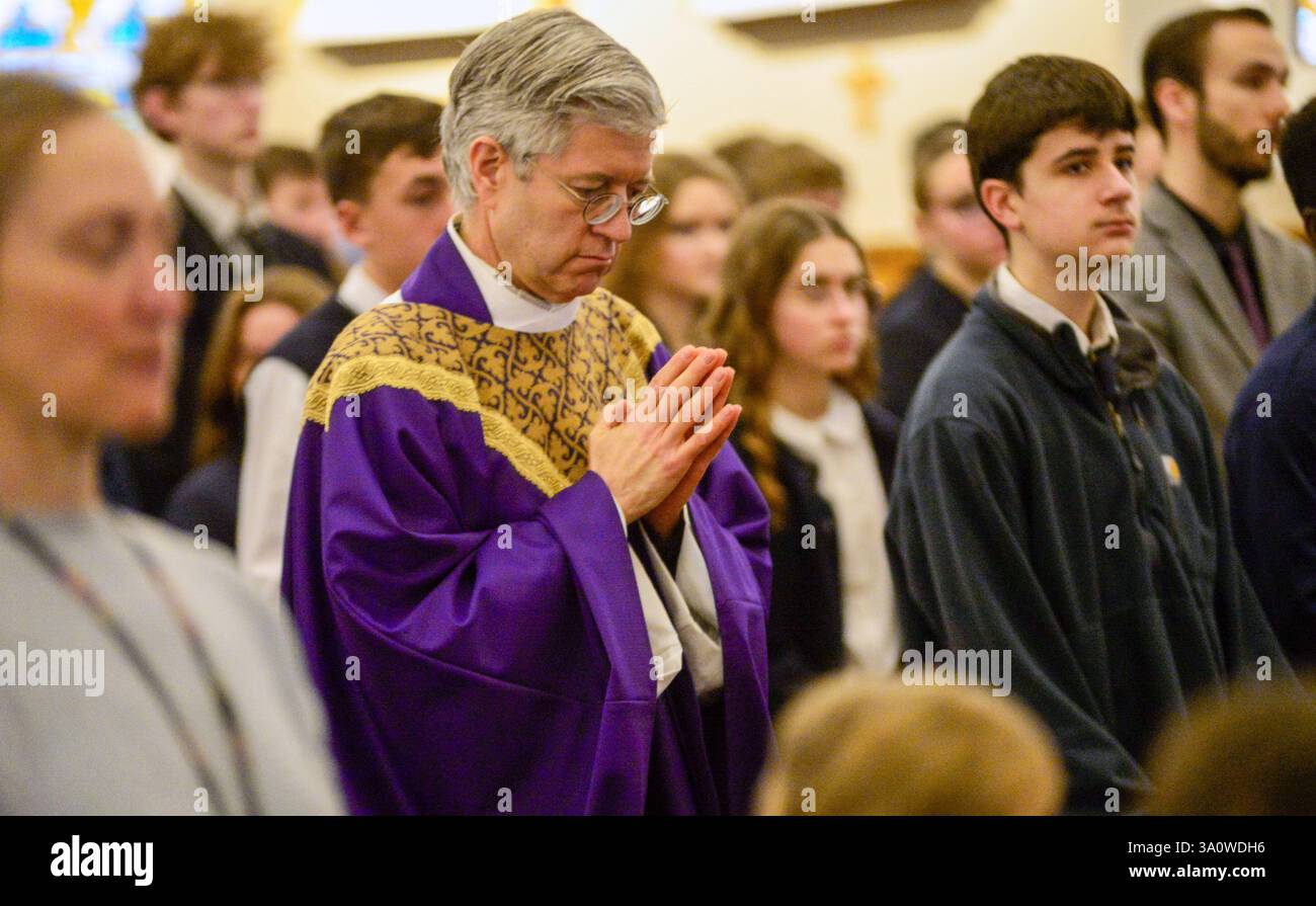 Father Henry Furman goes between the pews during the start of the Ash ...