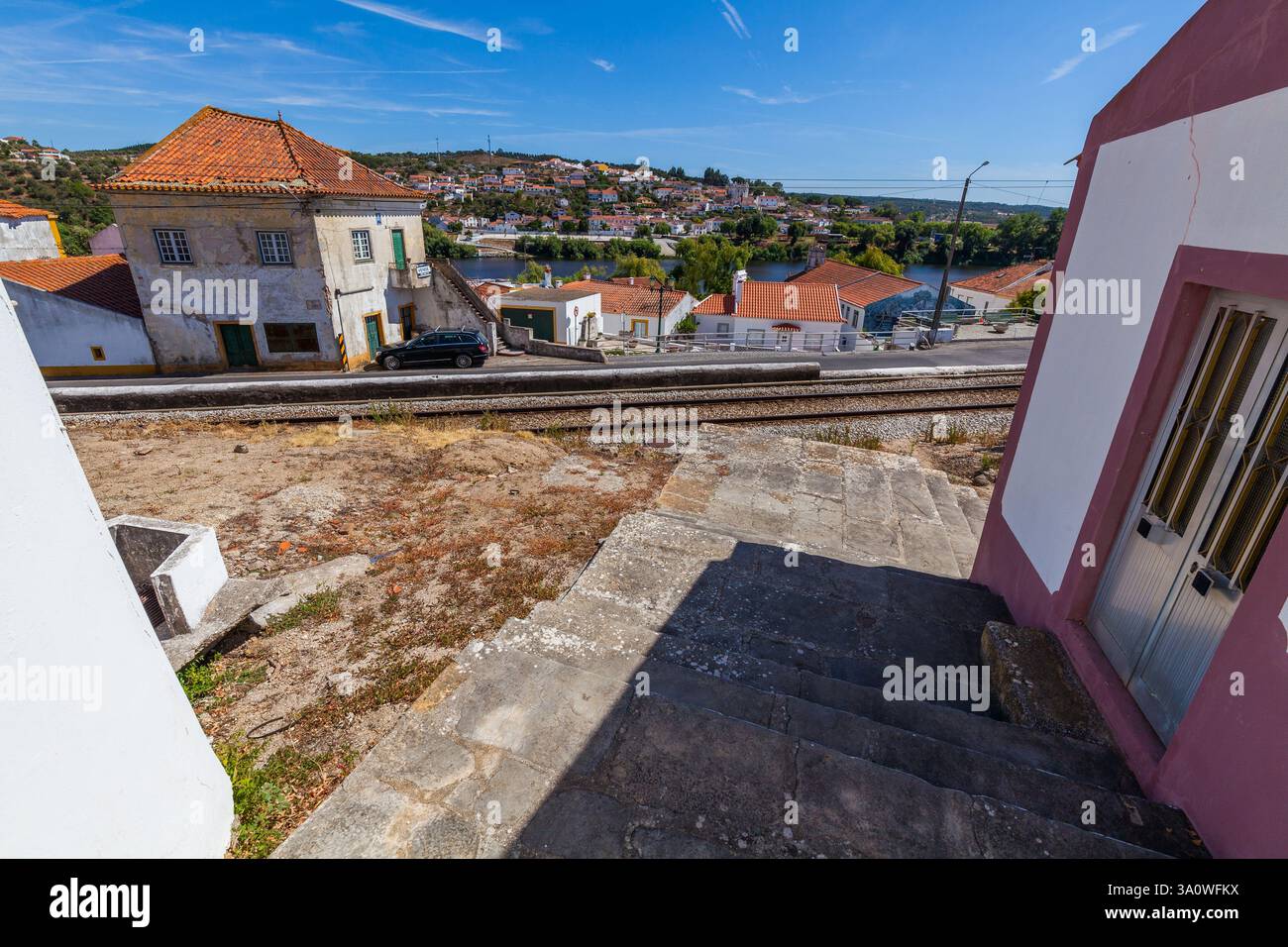 A tranquil village scene with railway tracks, traditional houses with ...