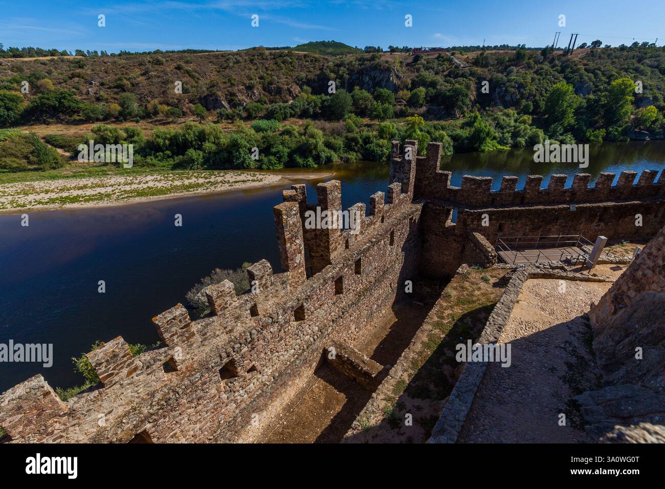 The rugged stone walls of the castle stand tall, overlooking a serene ...