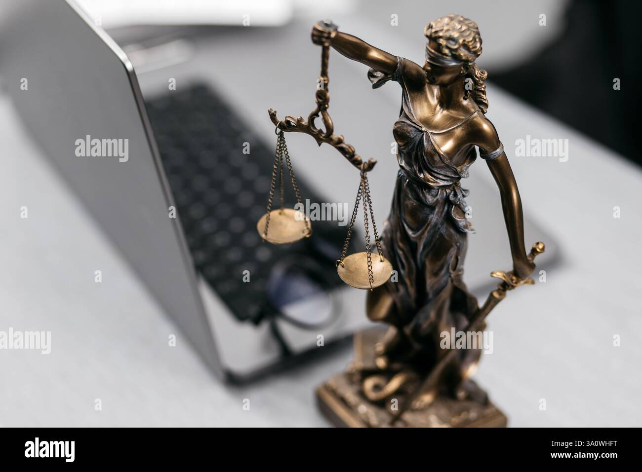 A lawyer sitting at their desk with the Statue of Themis, goddess of ...