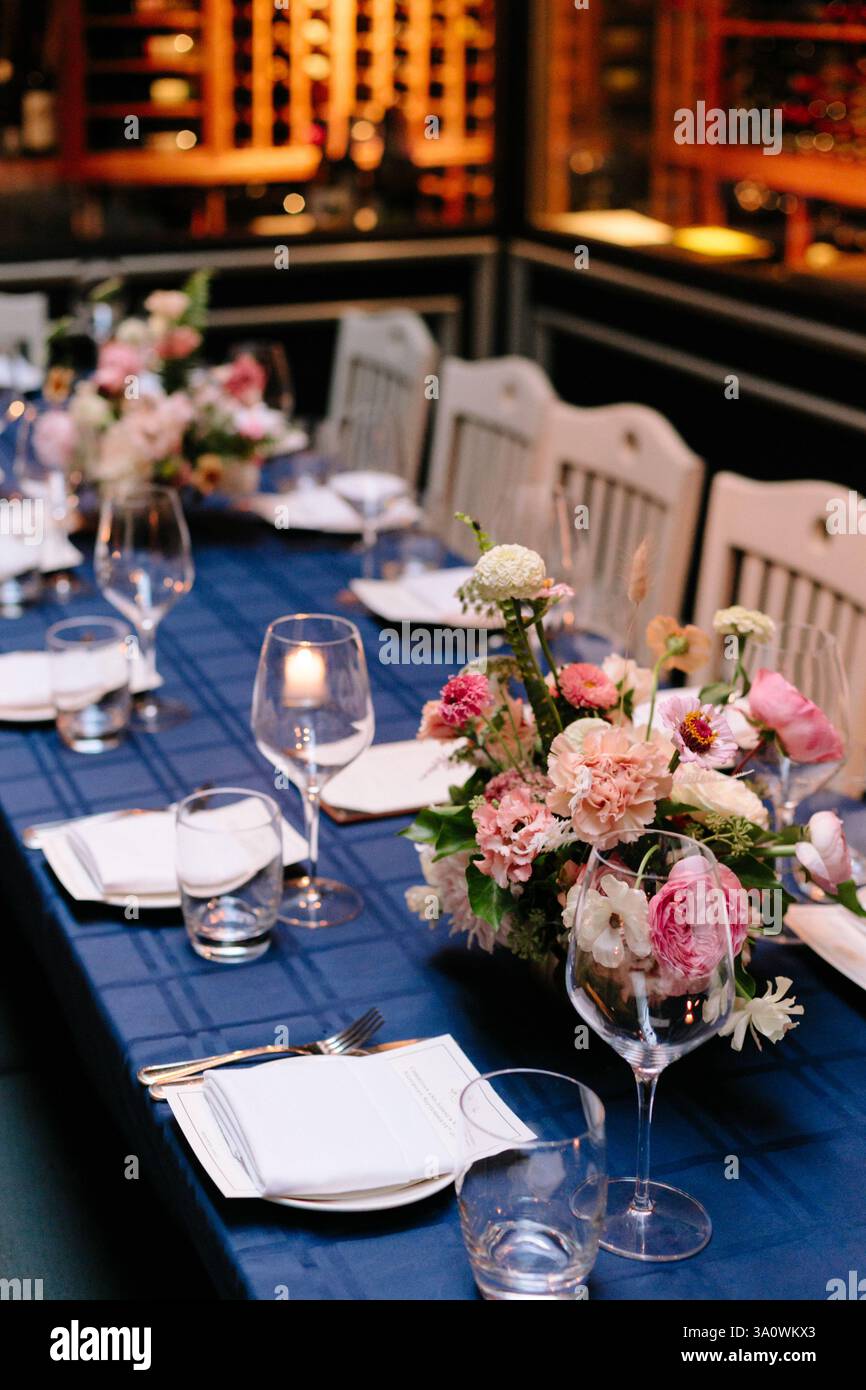 A beautifully arranged dinner table features floral centerpieces and ...