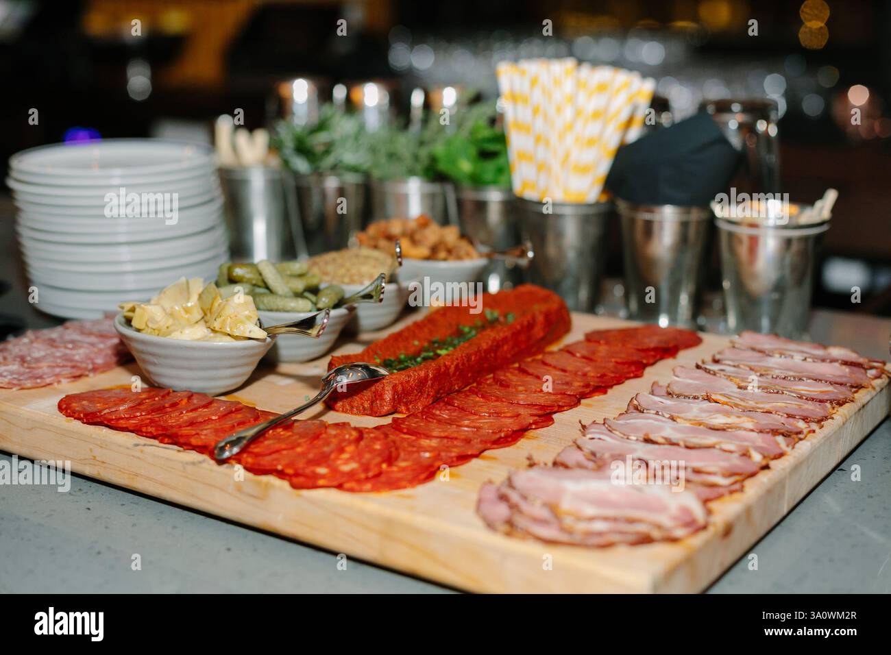 Guests enjoy a lavish spread of cured meats, pickles, and snacks at a ...