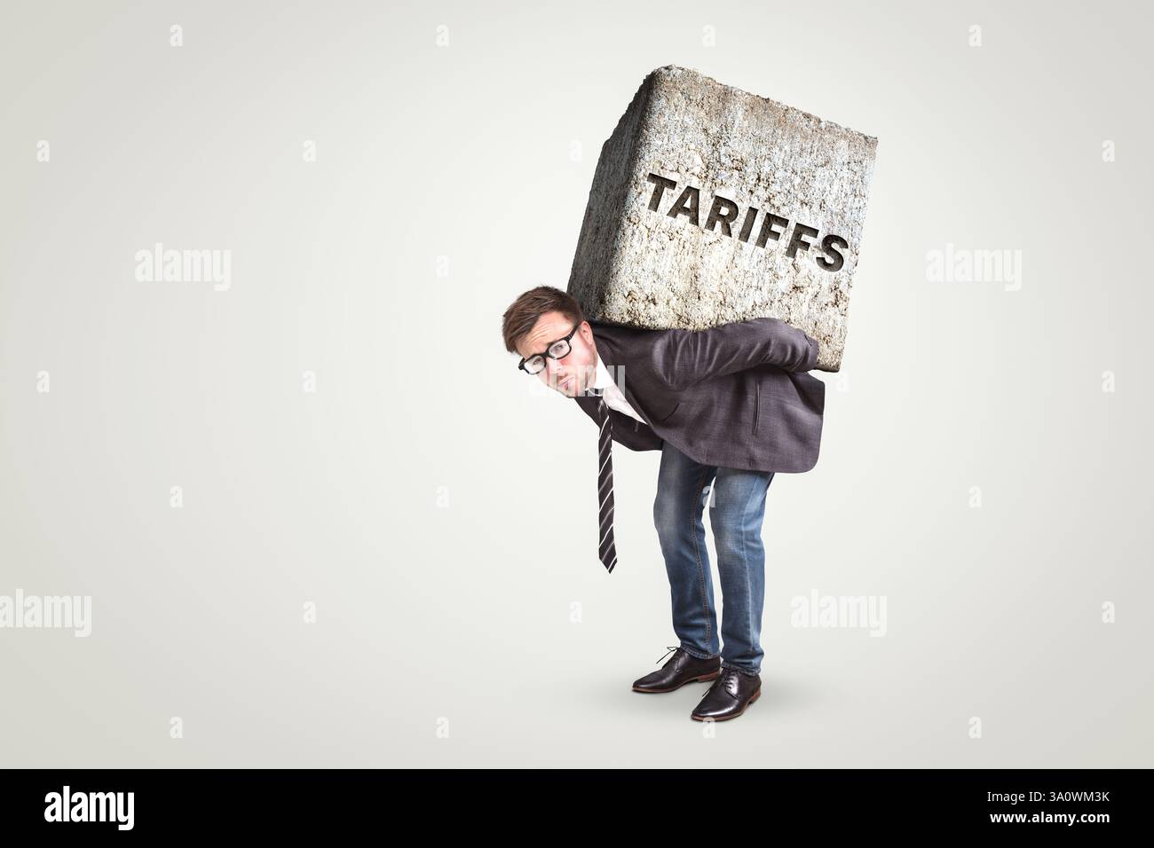 Person struggling under the negative impact of tariffs Stock Photo - Alamy