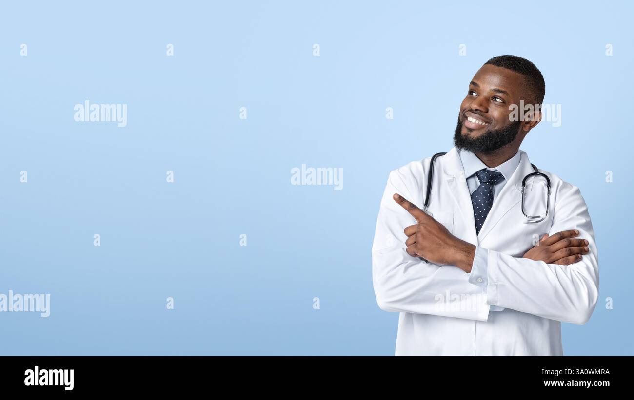 Positive african doc with arms crossed pointing at empty space Stock ...