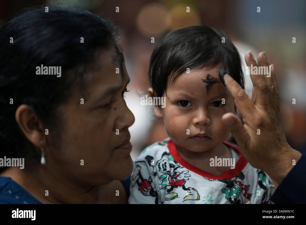 A child is marked with an ash cross during an Ash Wednesday service in ...