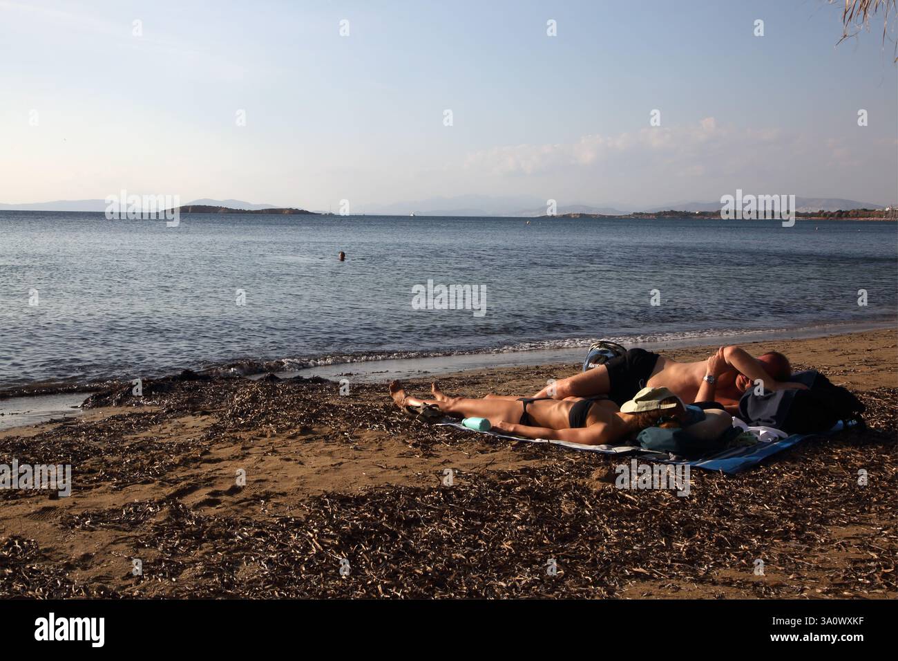 Couple sunbathing at the beach hi-res stock photography and images - Alamy