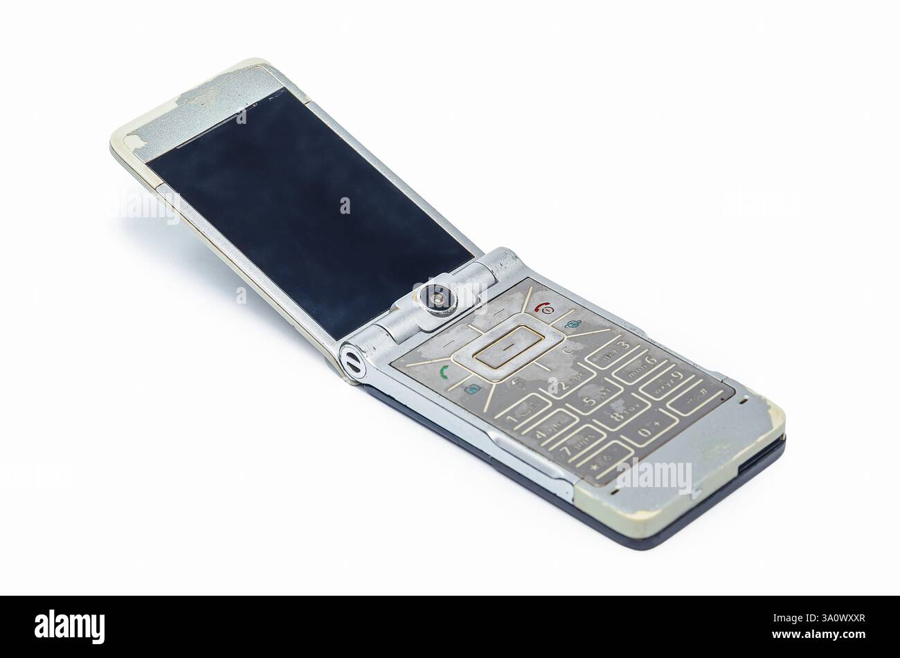 Vintage silver and beige flip phone with worn body on white background ...