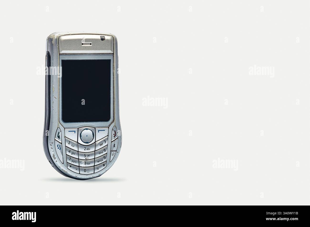 Vintage silver mobile phone with worn body on white Stock Photo - Alamy