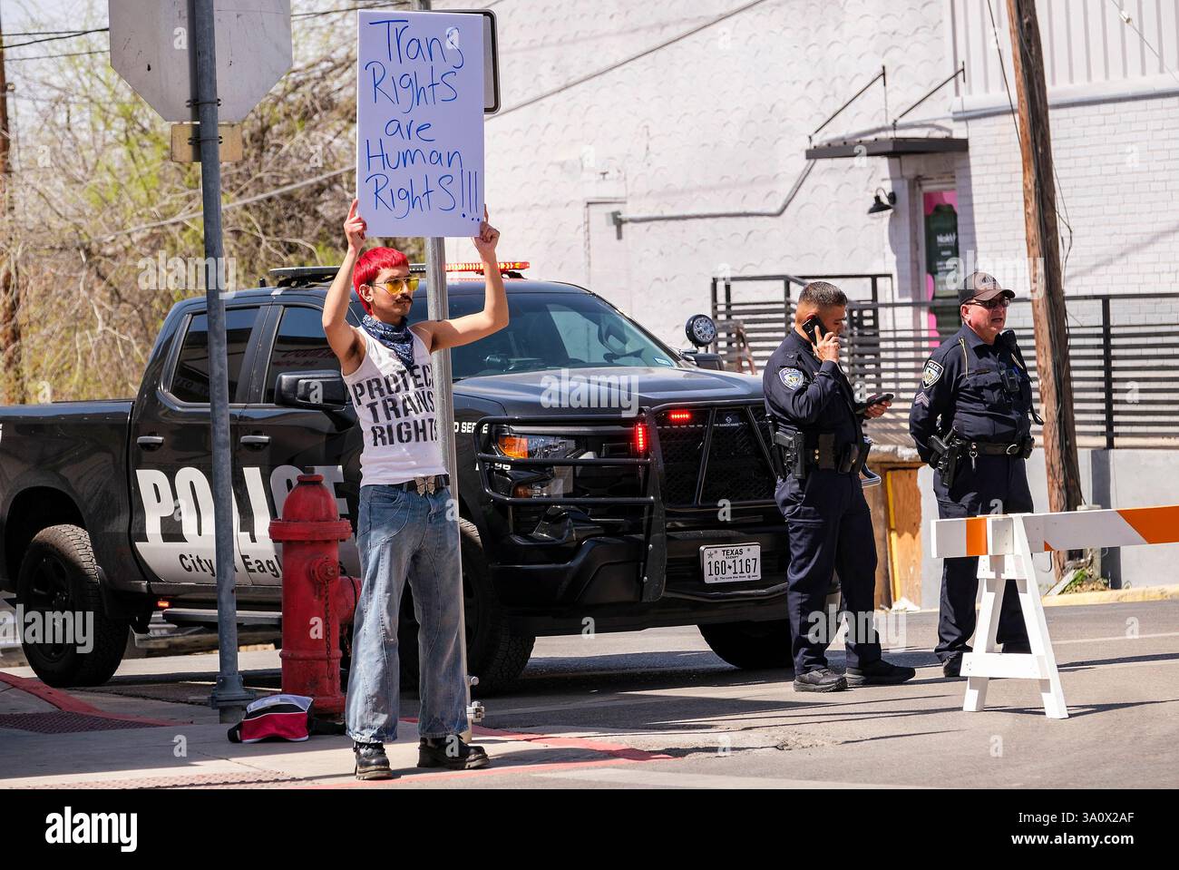 Indigo Beltran, 19, of Eagle Pass, holds a poster protesting the visit ...