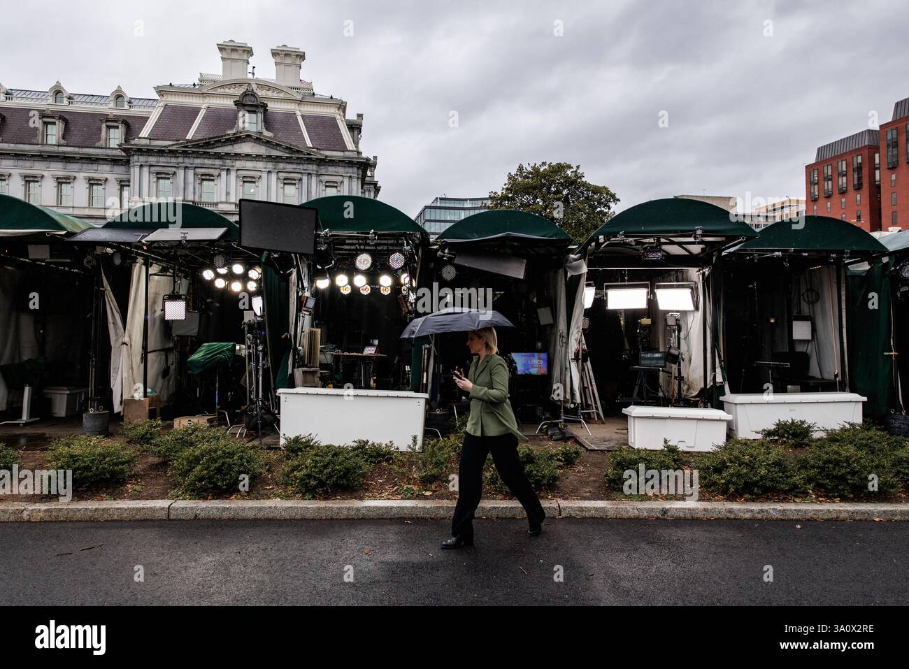 A reporter walks past a row of broadcast television booths along Pebble ...