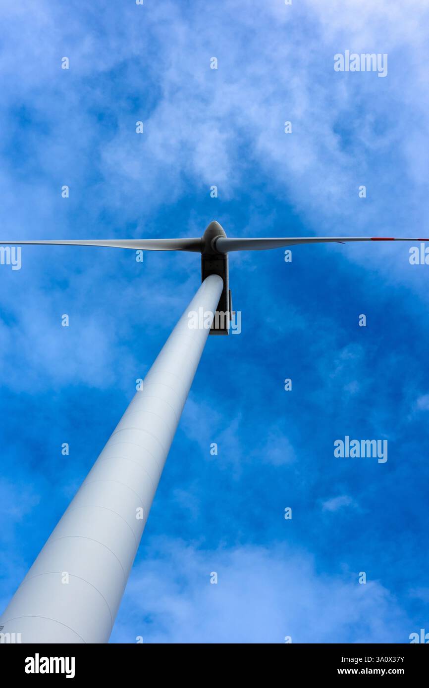 White wind turbine rotor against a blue sky background. Electric ...