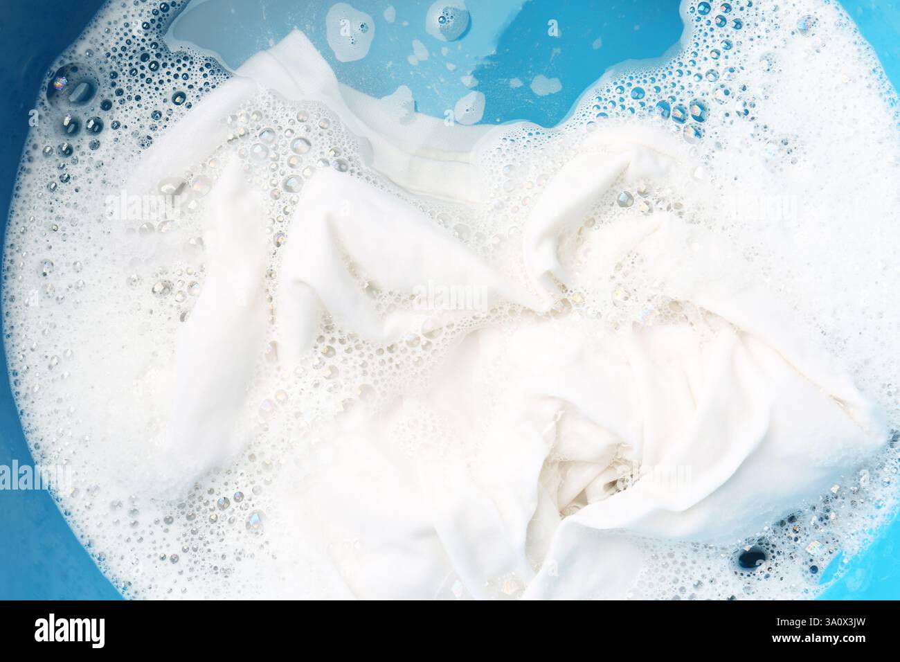White clothes soaked in water before washing, top view Stock Photo - Alamy