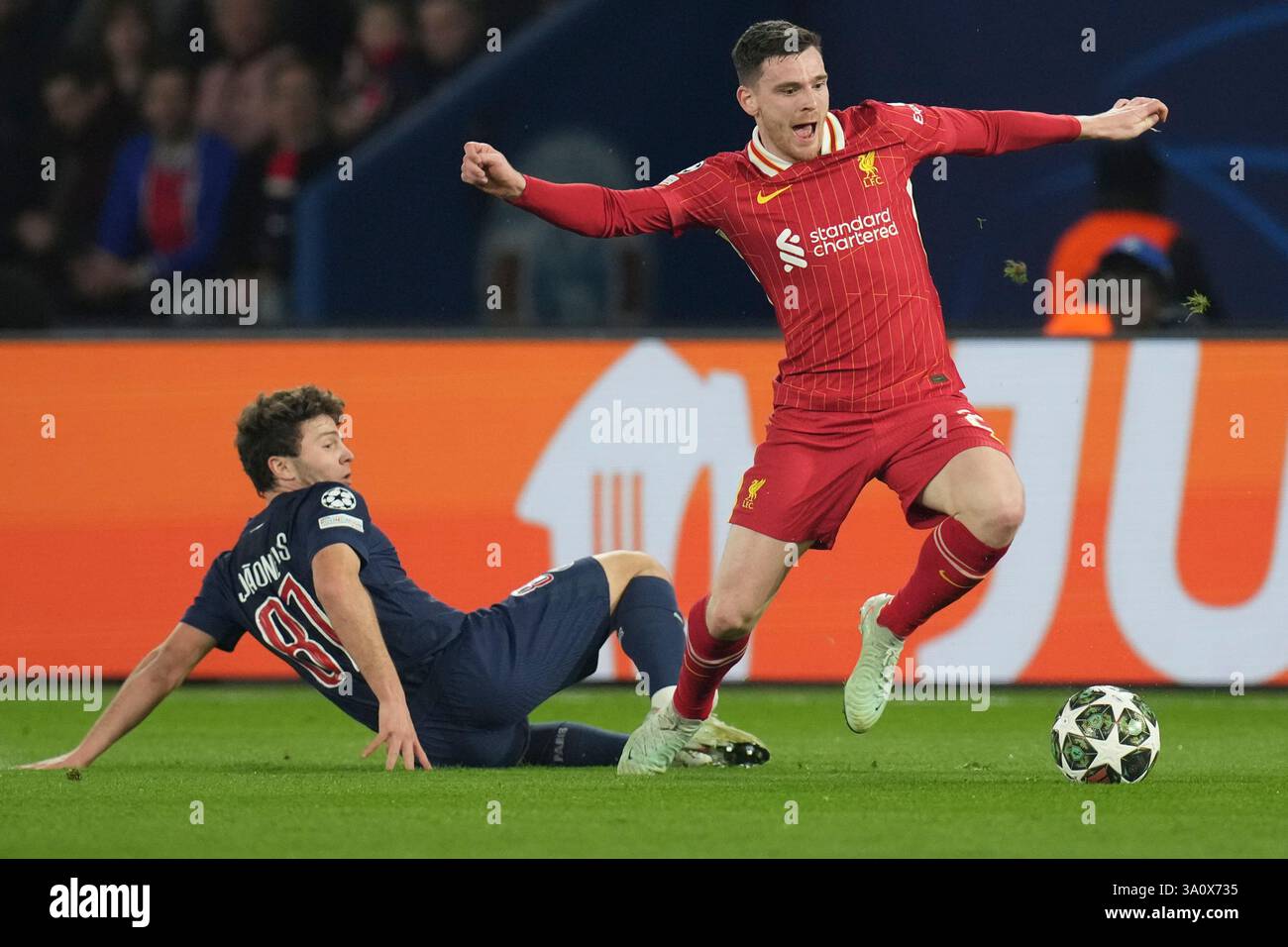 Liverpool's Andrew Robertson escapes the tackle by PSG's Fabian Ruiz ...