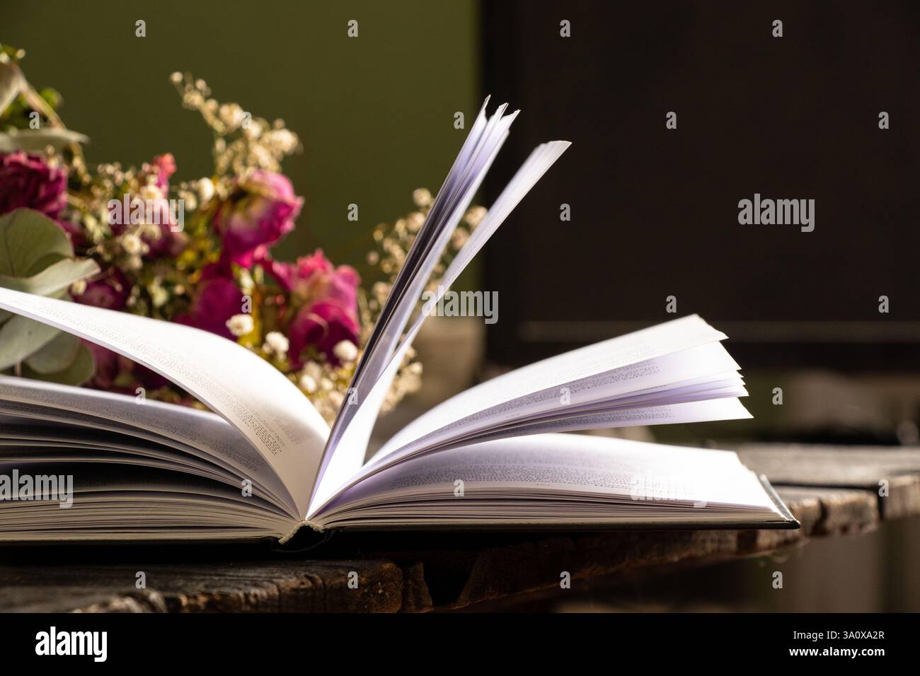 Open book on wooden table at home with dry roses bouquet in room Stock ...