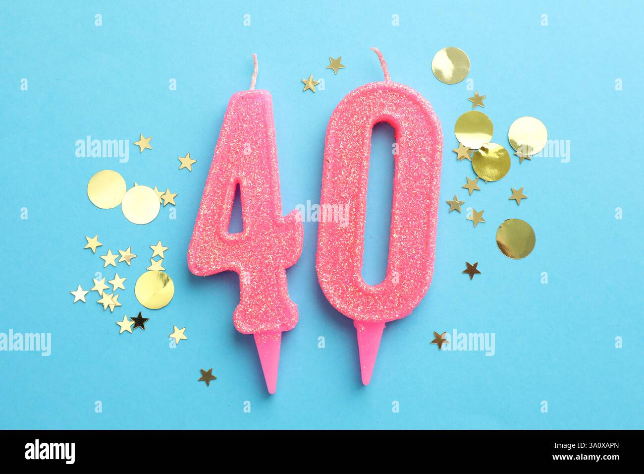 40th birthday. Number shaped candles and confetti on light blue ...