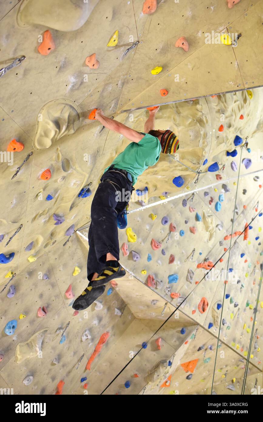 young sporty man bouldering in a climbing hall - indoor sports Stock ...