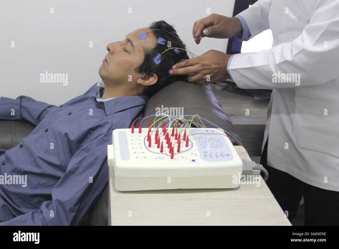 Electroencephalogram EEG in adult Latino man with wires in his head ...