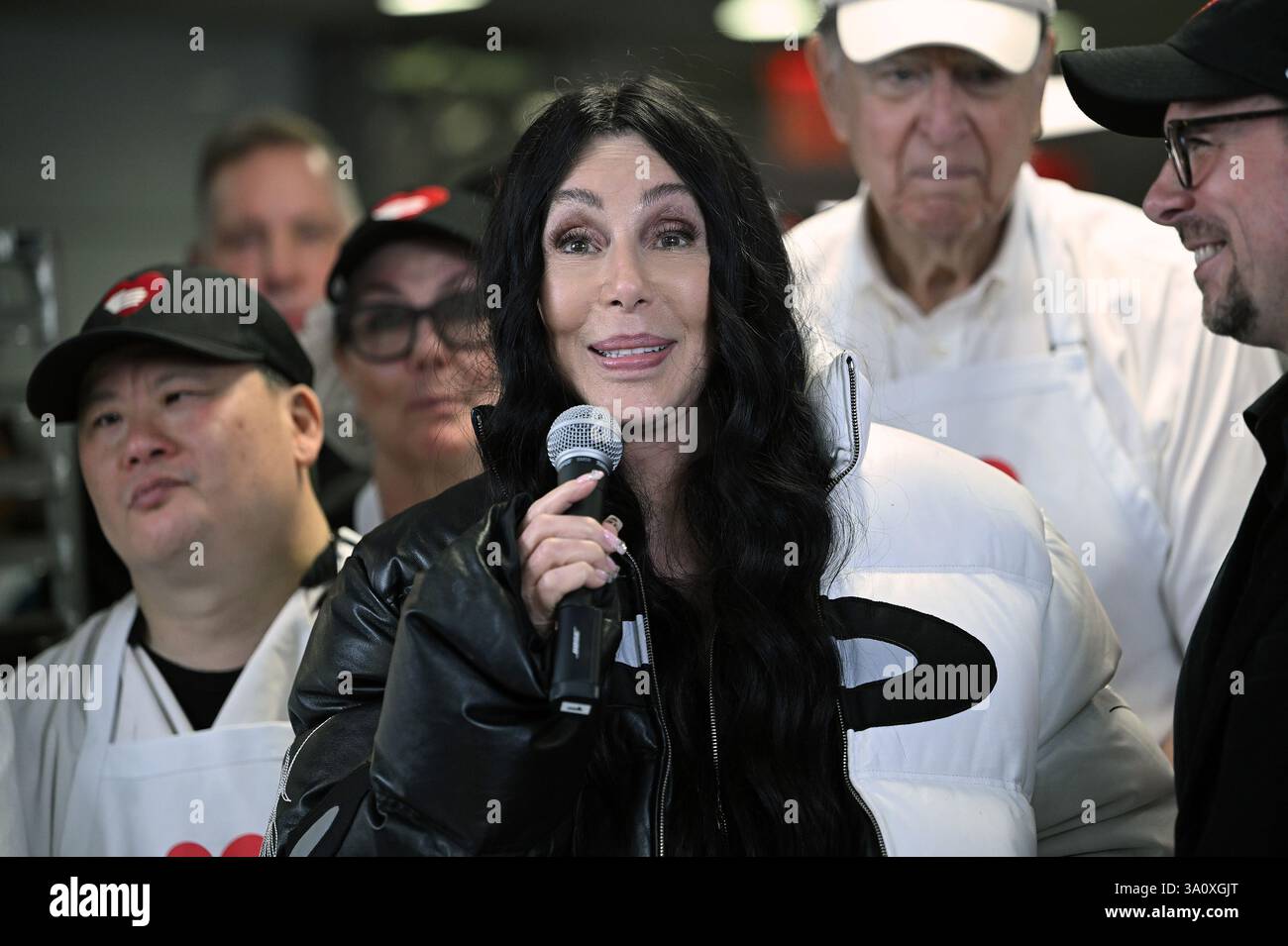 American singer Cher (center) visits with volunteers and kitchen staff ...