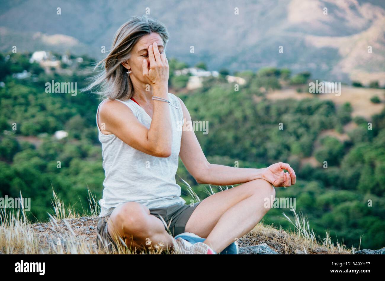 Woman practicing breathing exercises with a mountain landscape ...