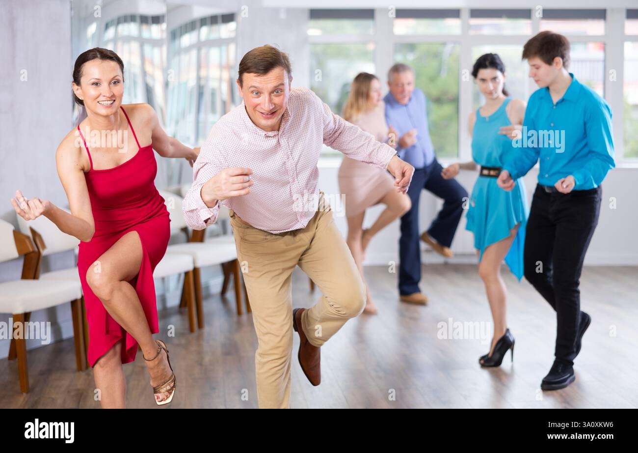 Group is of different ages active people engaged in Latin dance studio ...