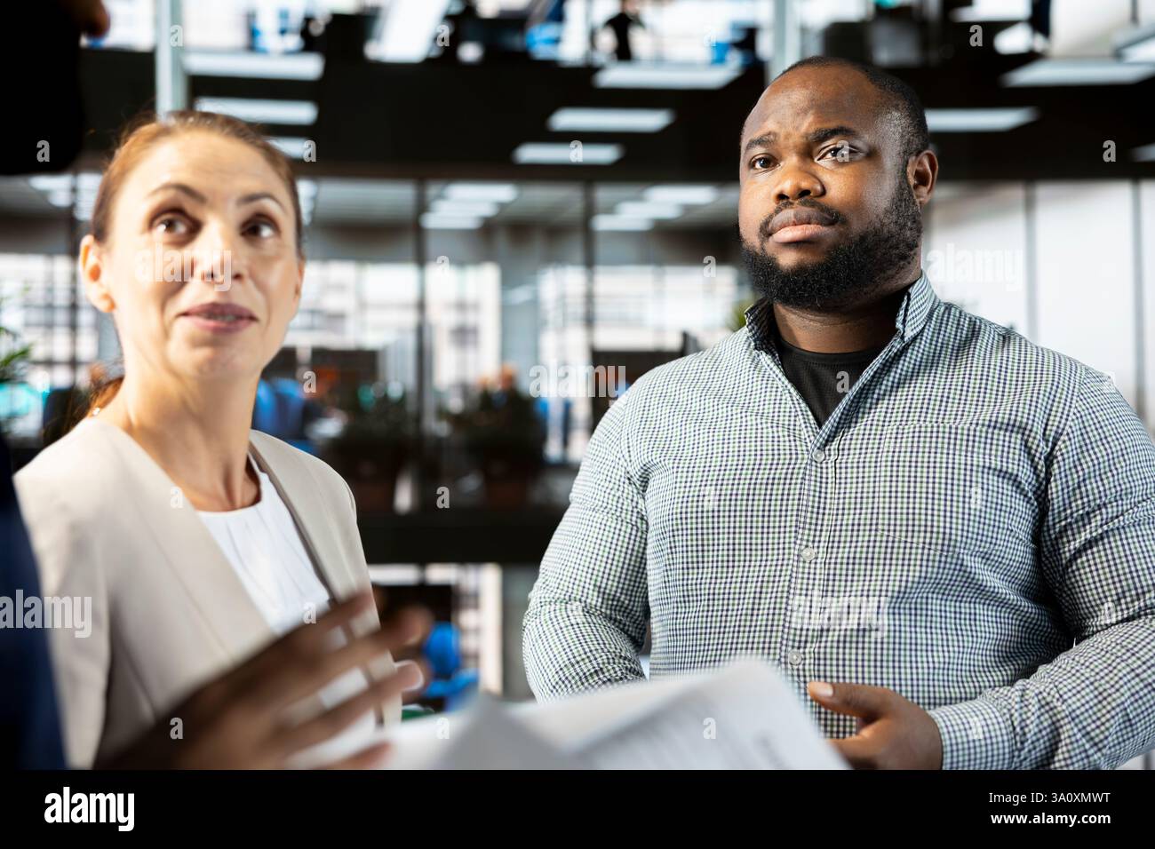 Teamworking colleagues in company office checking progress on customer commissioned project ...