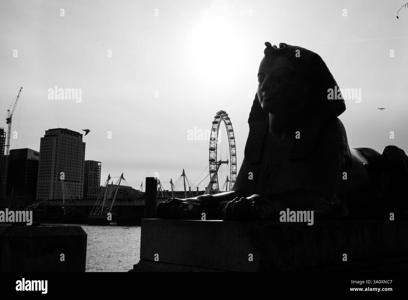 The London Eye and the Sphinx statue, on the banks of the River Thames ...