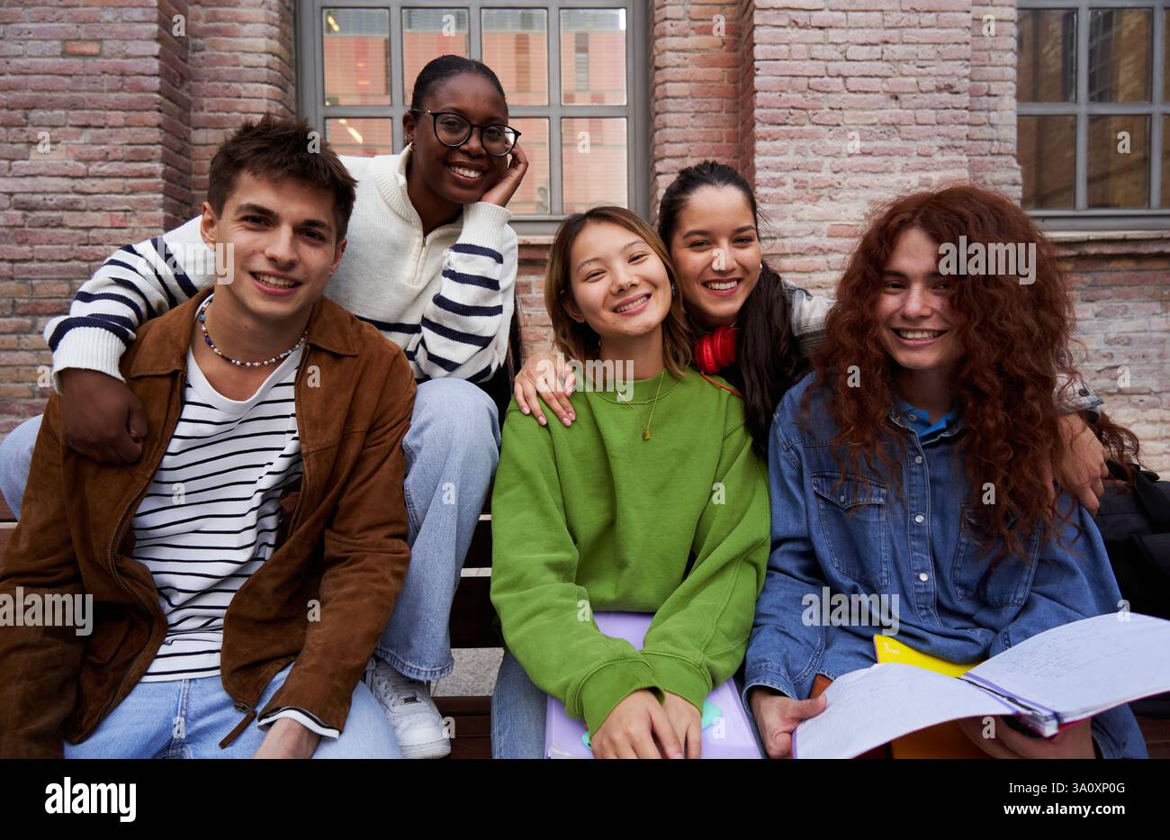Portrait of a group of student friends gathering at university campus ...