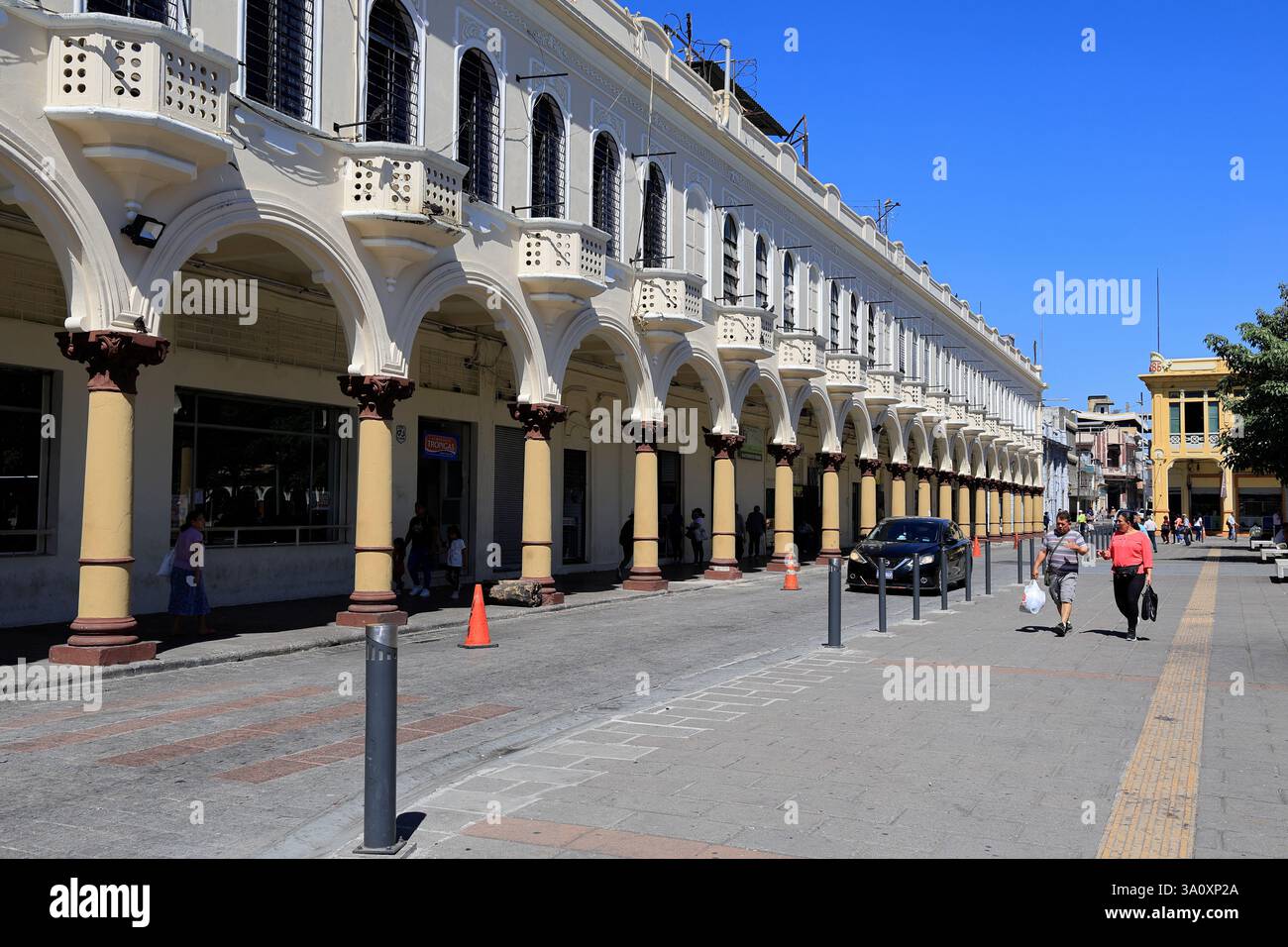 Colonial style building with arched walkway surrounded Plaza Libertad ...