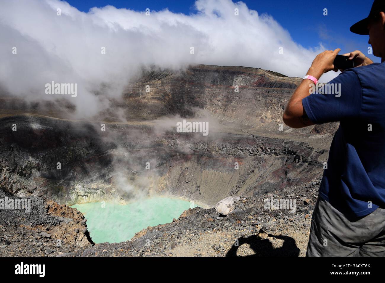A tourist taking photo of mint green Ilamatepec Lake at the crater of ...