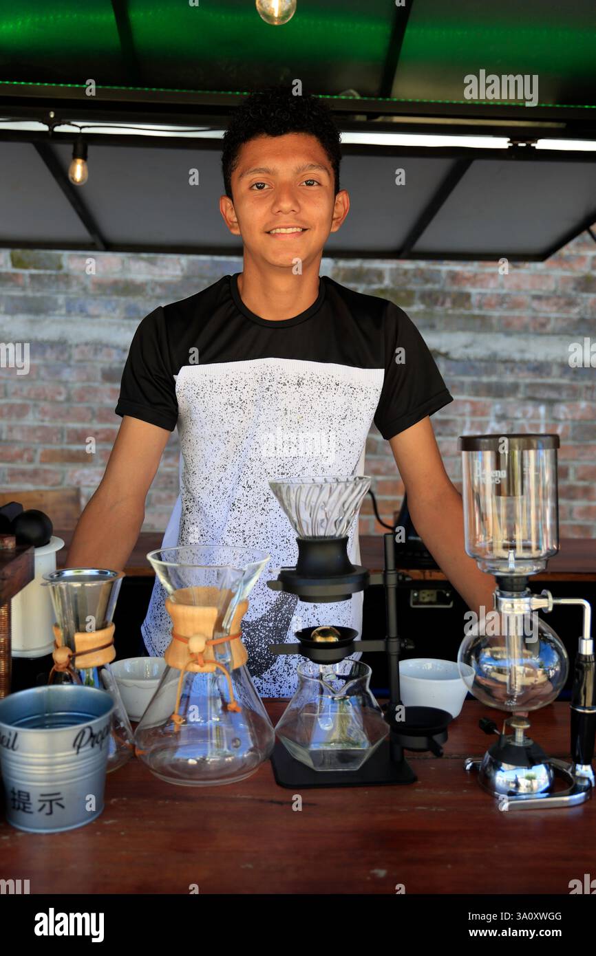 The portrait of a young male baristas working in a mobile coffee stall ...