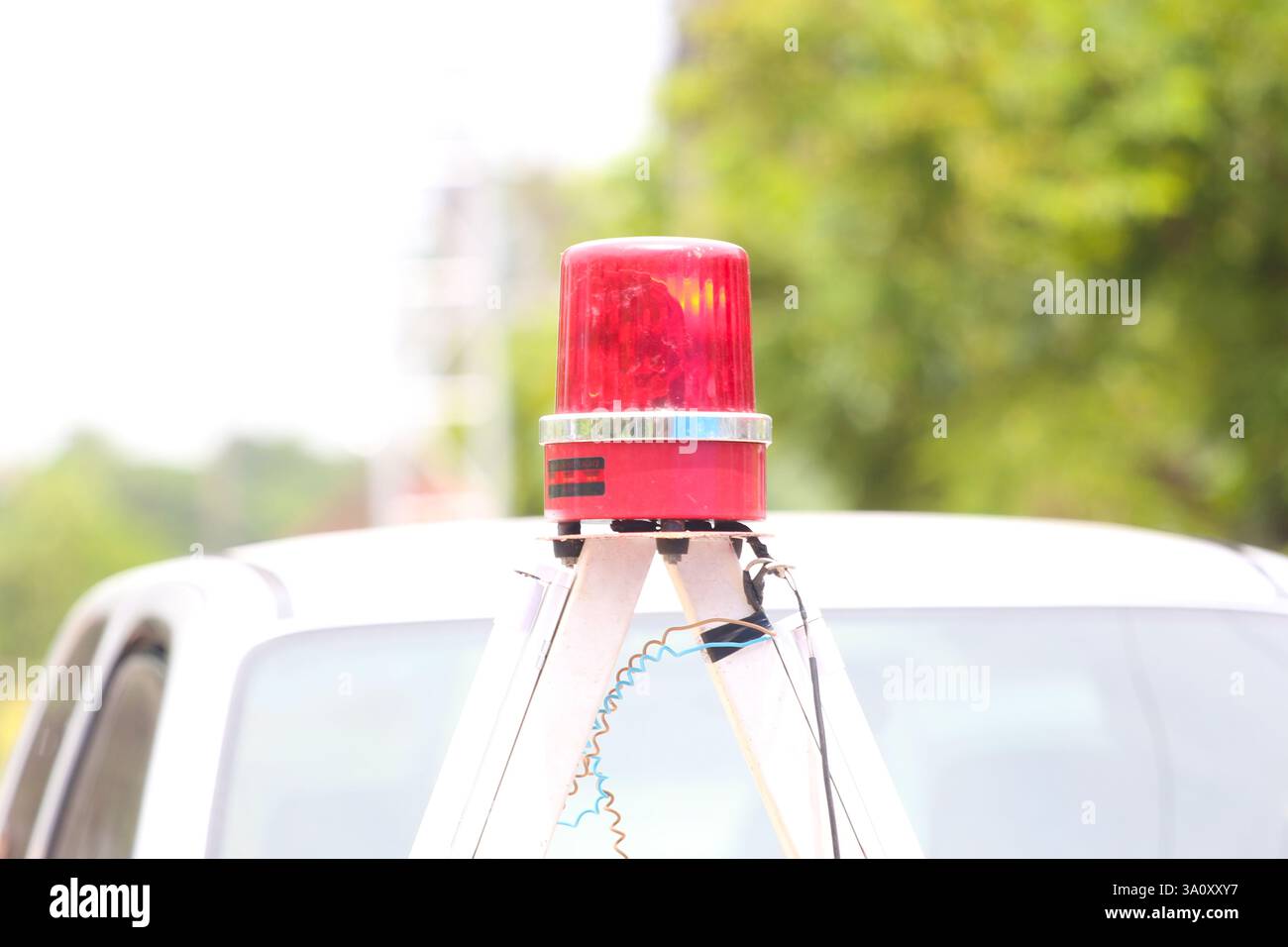 A close-up of a red emergency light mounted on a vehicle roof ...