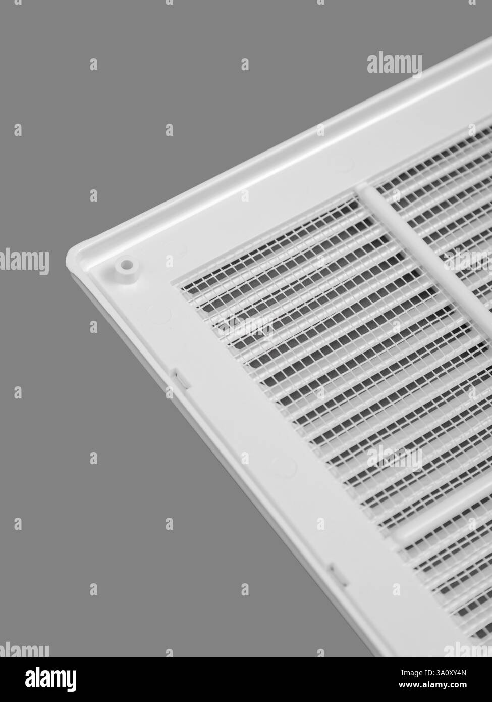 White ventilation grate on a gray background. Close-up. Material is ...