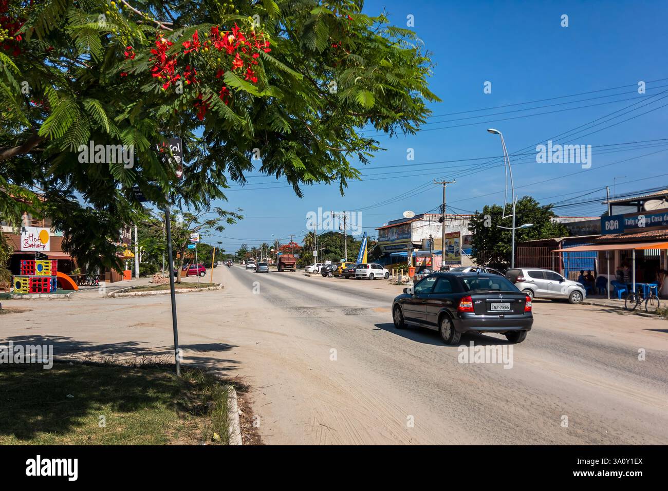 Traffic passing along Estrada de Praia Seca road (RJ-102), close to small local shop business of ...