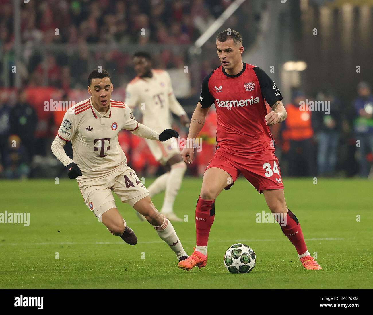 Munich, Germany. 5th Mar, 2025. Jamal Musiala (L) of Bayern Munich vies with Granit Xhaka of ...