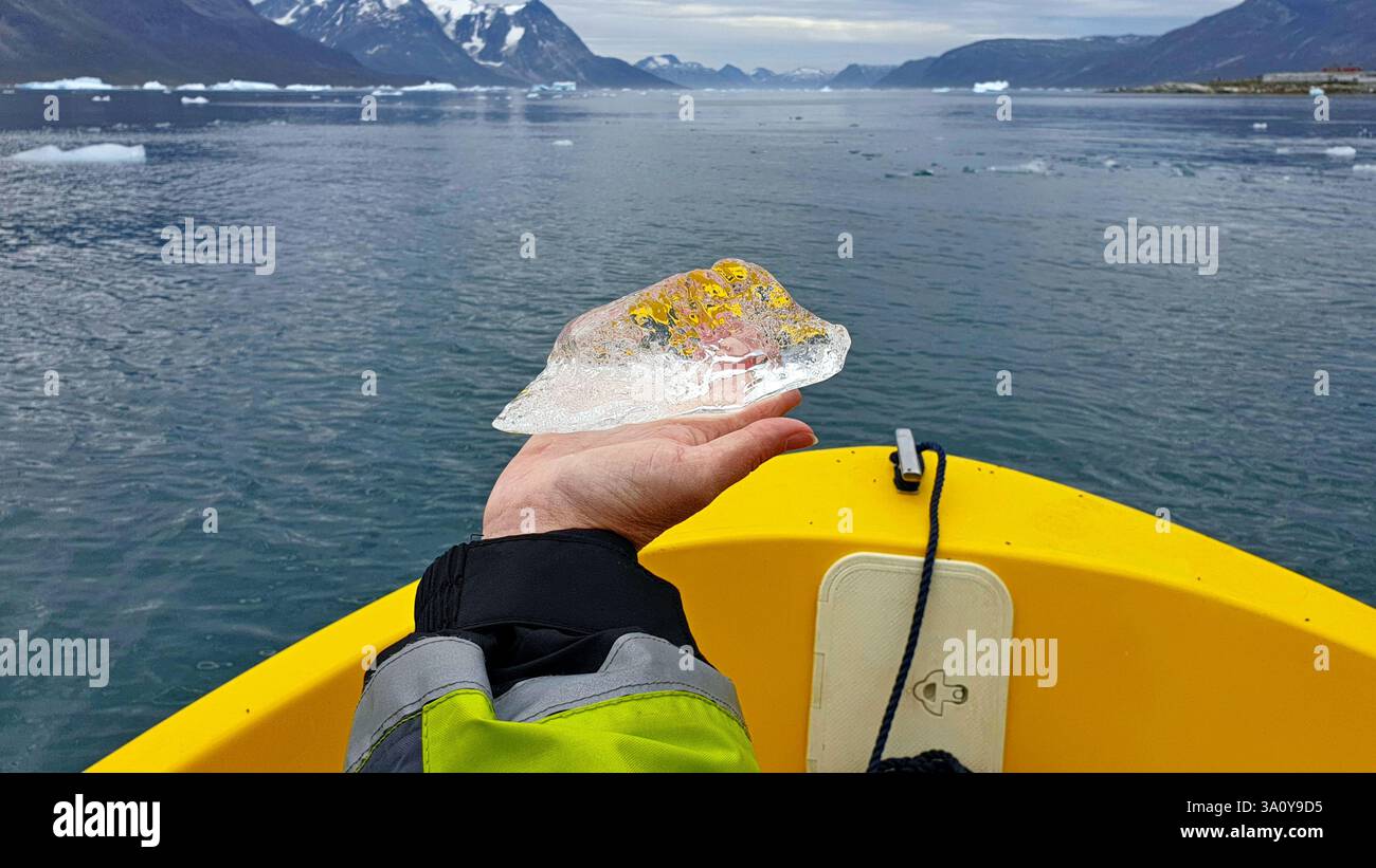 The hand of a female traveler, sailing in a yellow boat through the ...