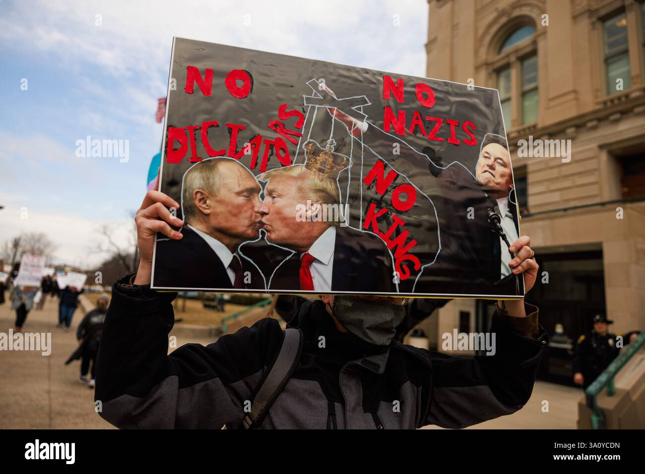 A protester holds a sign reading “No dictators, No Nazis, No King ...