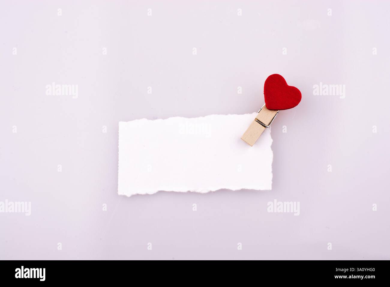 Red hearted clip on an empty torn paper Stock Photo - Alamy