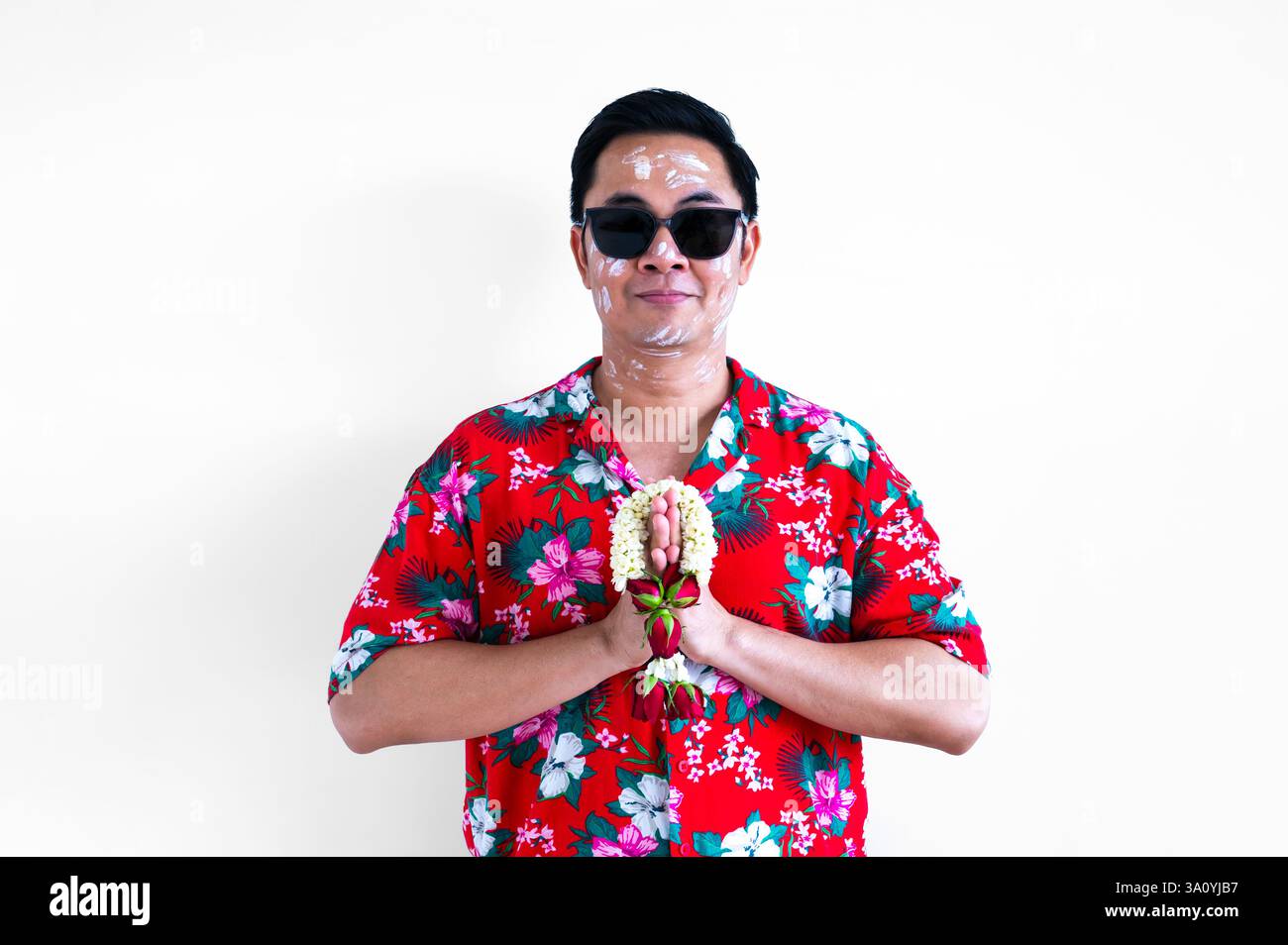 Thai male with white clay filler on face wearing colorful shirt doing ...