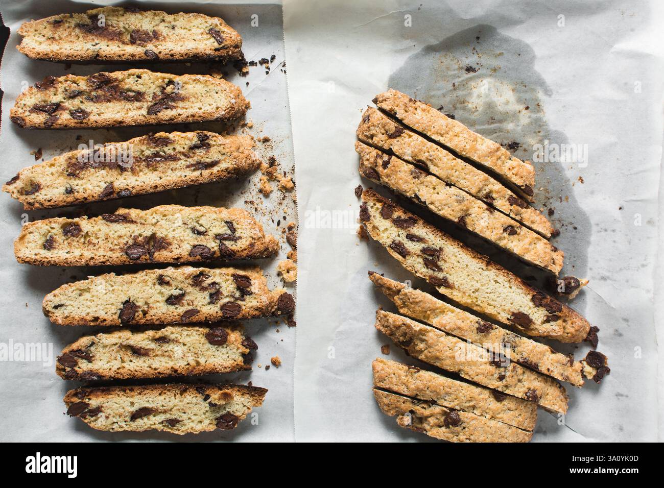 Overhead view of chocolate chip biscotti on white parchment lined tray ...