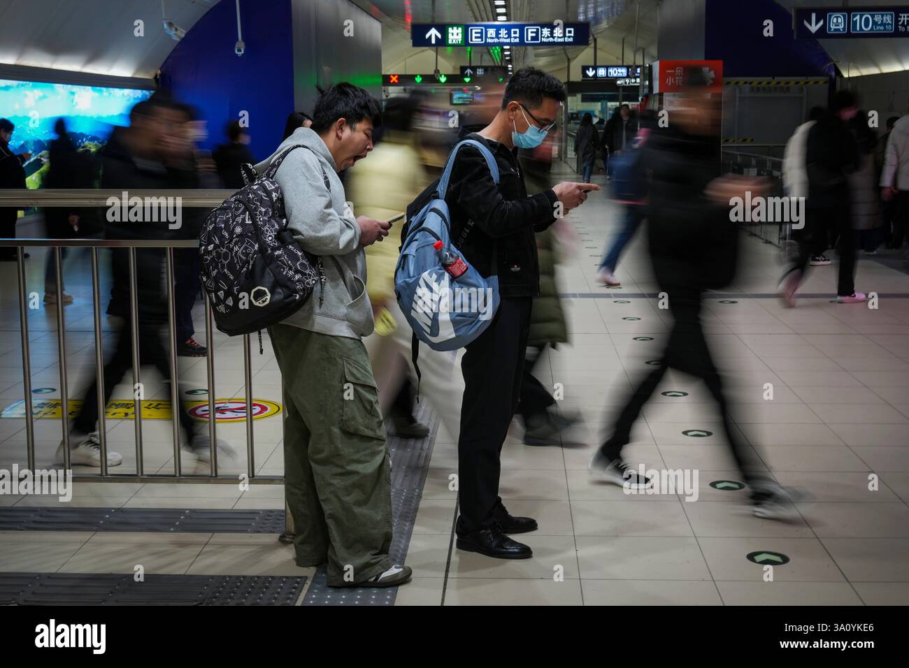 A man yawns as commuters rush to catch their trains at an interchange ...