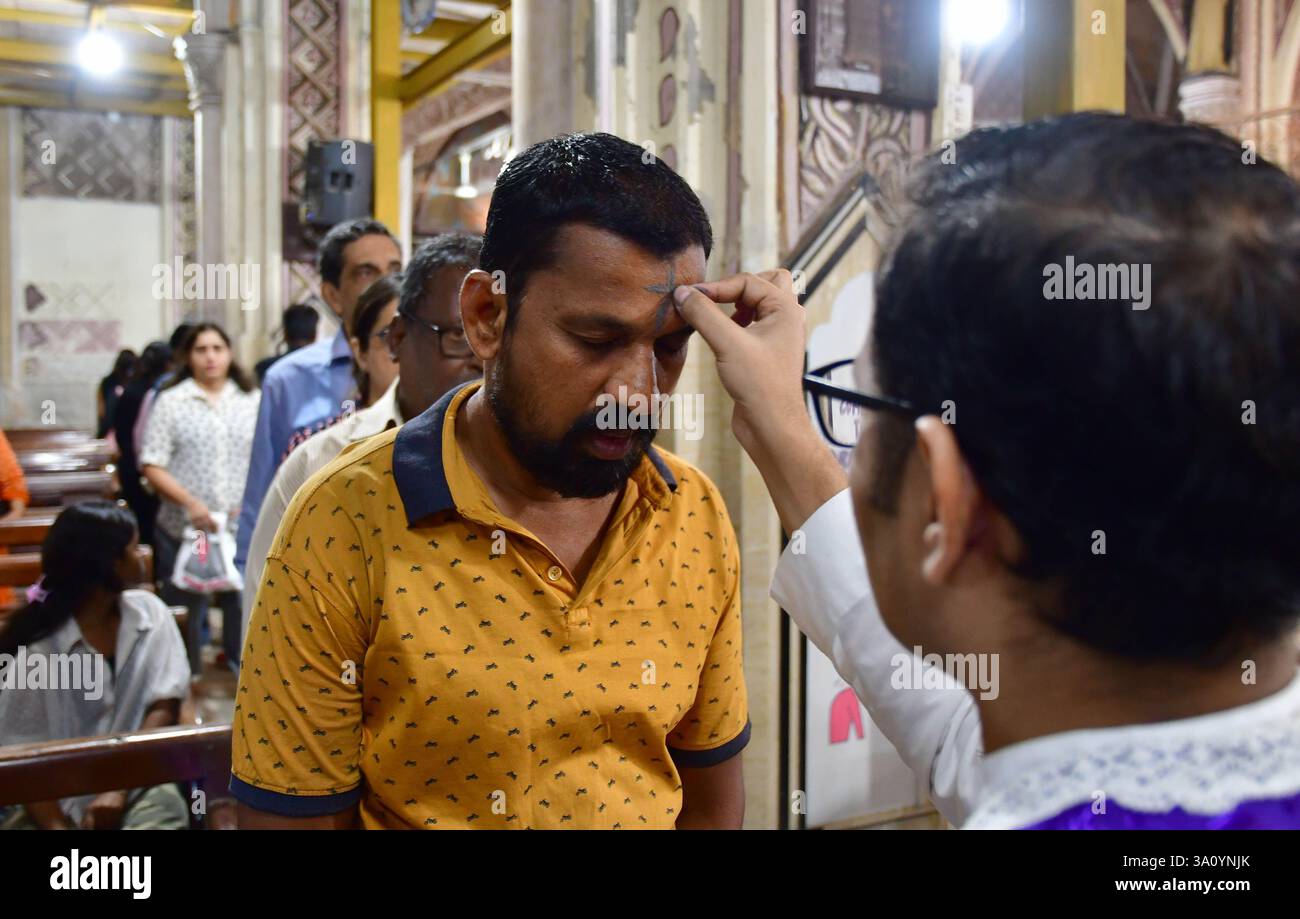 MUMBAI, INDIA - MARCH 5: A Catholic priest marks the symbol of the ...