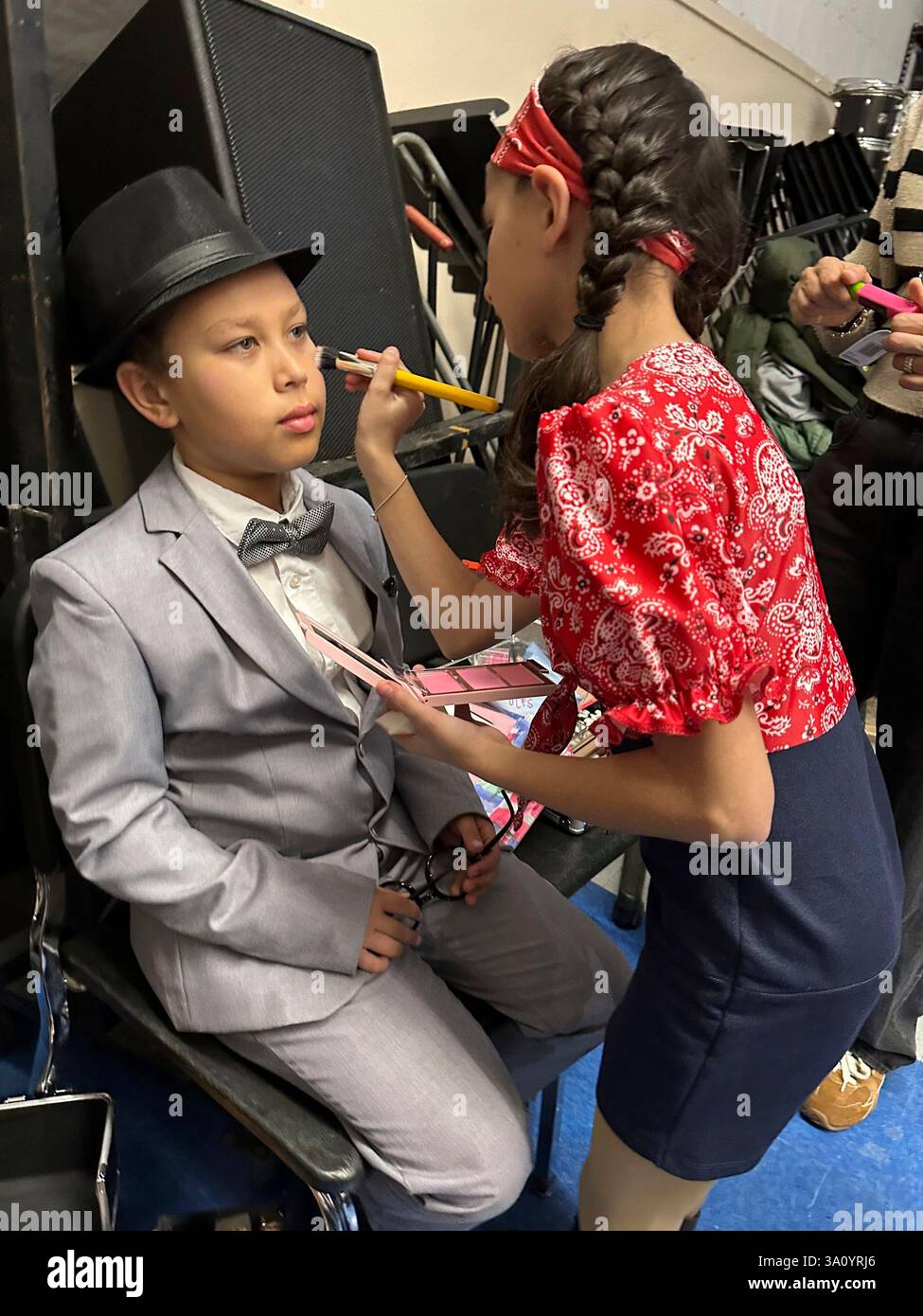 Tristan Oles, 12, left, gets makeup done by castmate Ava Maskouri, 10 ...