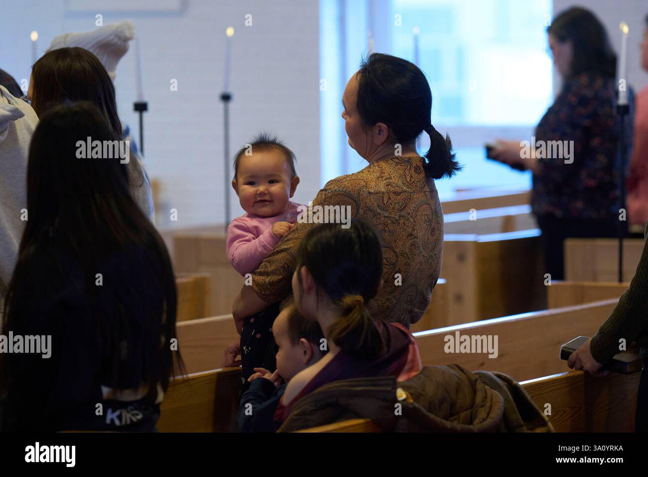 A baby is held by her mother as they attend a religious service at Hans ...
