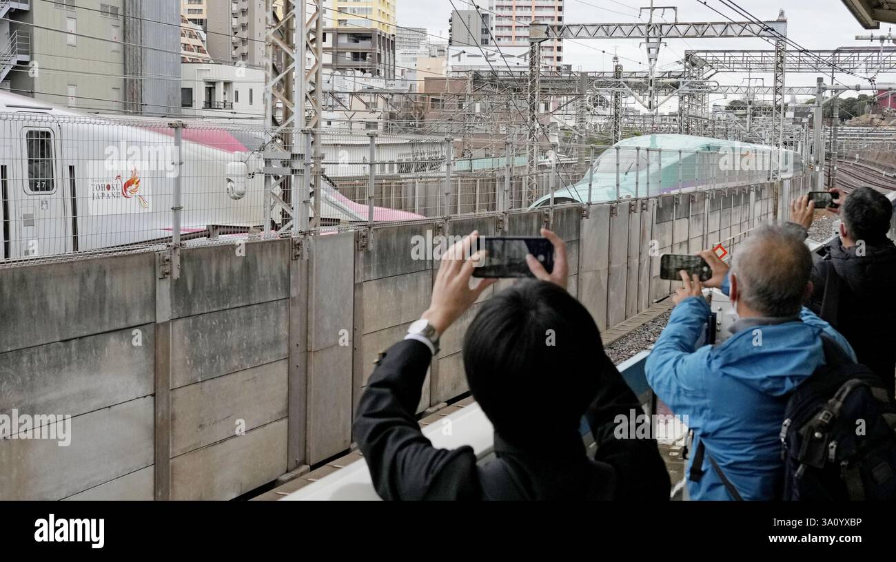 People take photos of a bullet train on the Tohoku Shinkansen Line ...