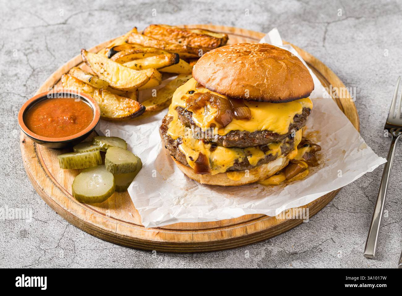 Smash burger with cheddar cheese and caramelized onions, served with ...