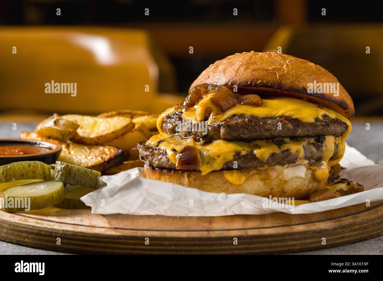 Smash burger with cheddar cheese and caramelized onions, served with ...