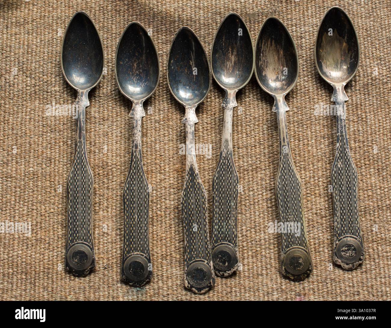 Stylish steel teaspoons on a textured background in display Stock Photo ...